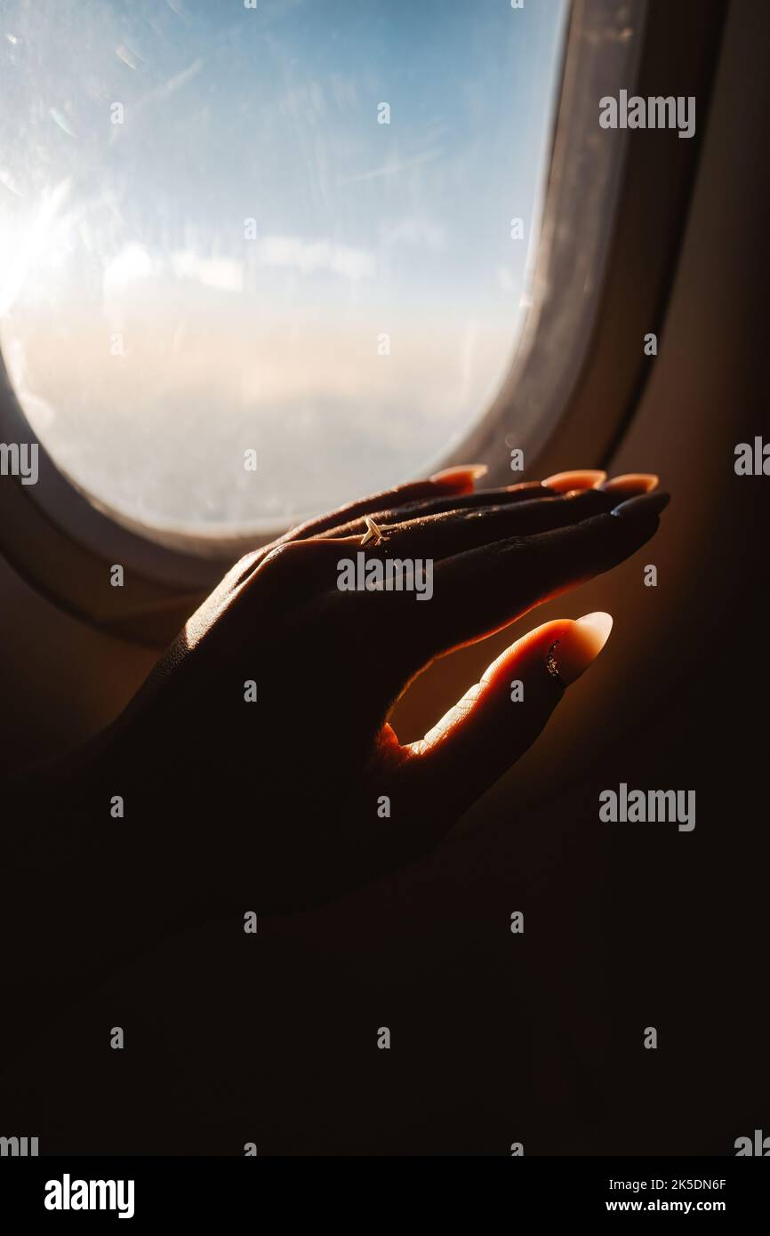 A vertical closeup of a female hand with a plane ring on the ring ...