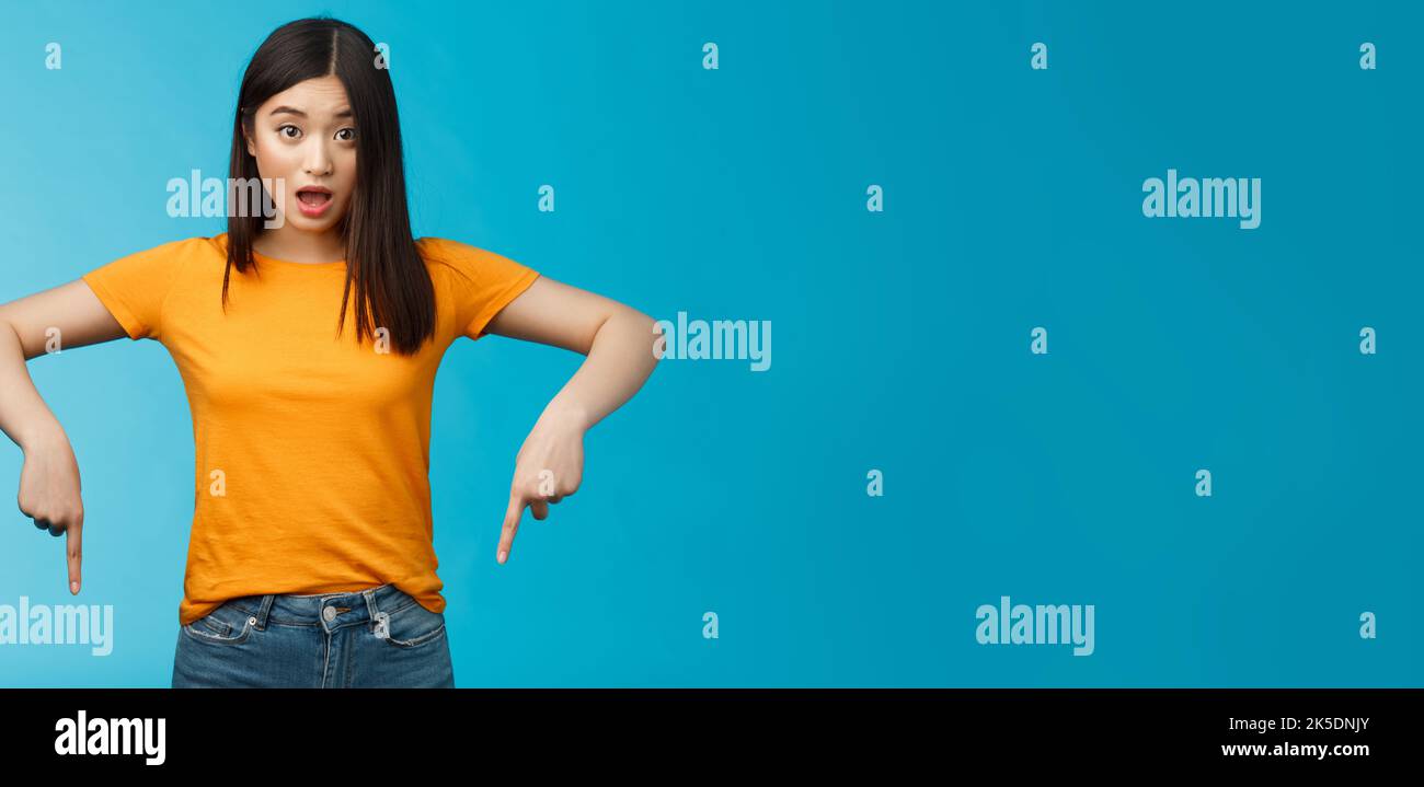 Impressed asian girl drop jaw shocked look camera surprised pointing ...