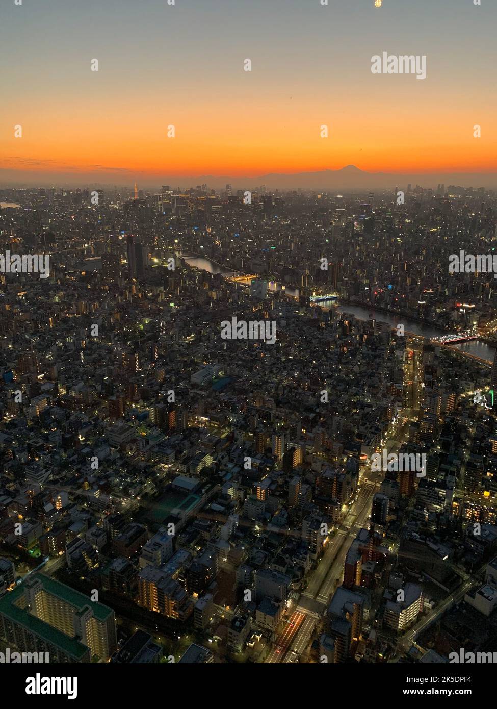 An aerial view of Tokyo Skyline with sunset orange sky on the horizon ...