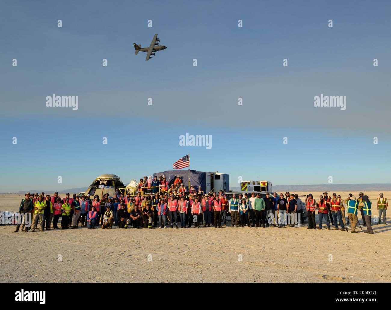 NASA and Boeing teams pose for a group photo as a USAF HC-130J Hercules ...