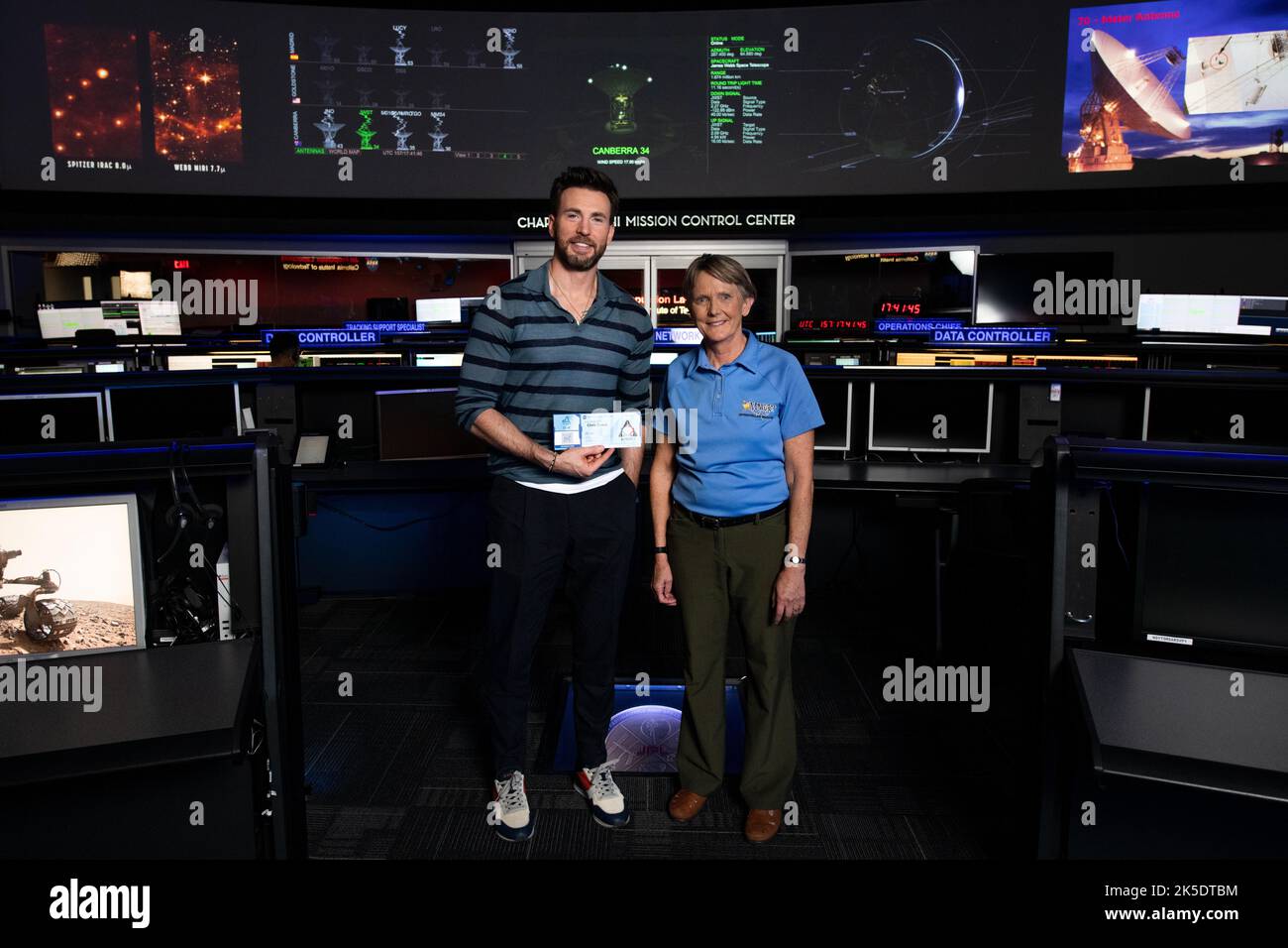 Actor Chris Evans (left) receives a boarding pass to the Moon from ...