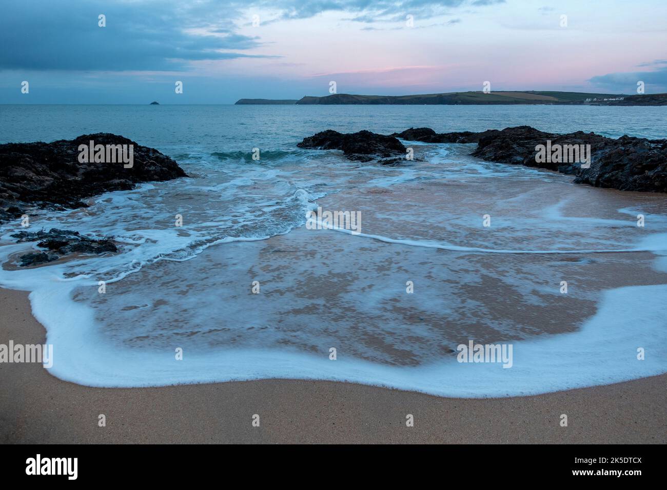 Gentle waves breaking at twilight on Harlyn Bay beach on the north ...