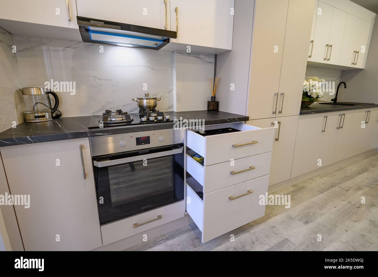 Luxury beige and cream kitchen interior details, some drawers retracted ...