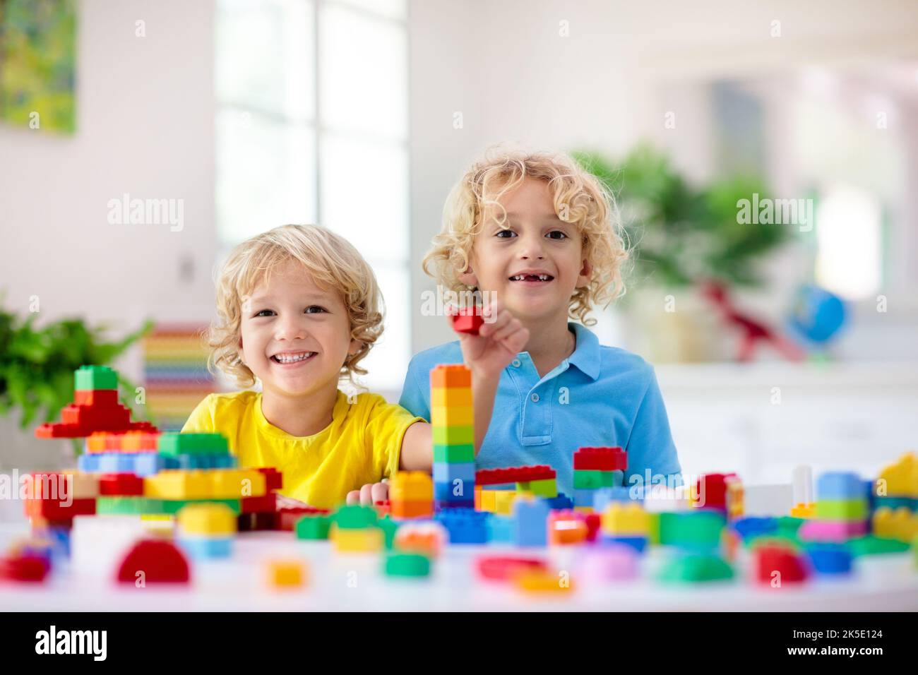 Kids play with colorful blocks. Little boy building tower at home or ...
