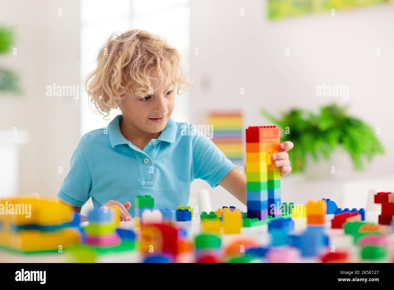 Kids play with colorful blocks. Little boy building tower at home or ...
