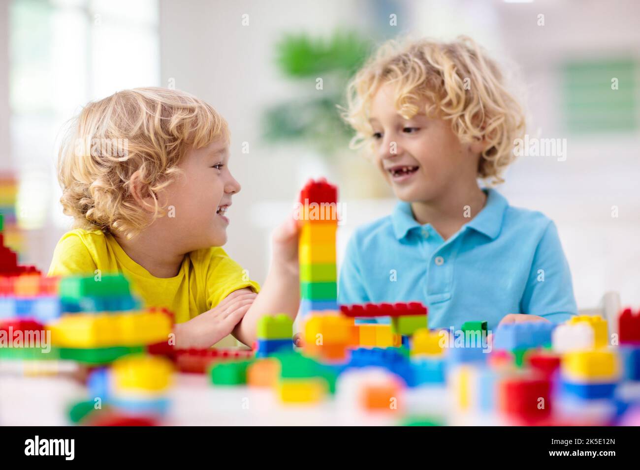 Kids play with colorful blocks. Little boy building tower at home or ...