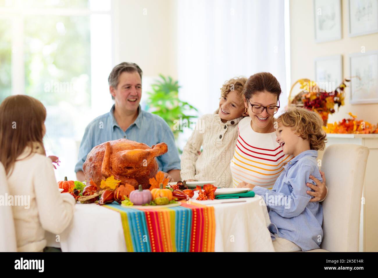 Family at Thanksgiving dinner. Parents and kids enjoy roasted turkey ...