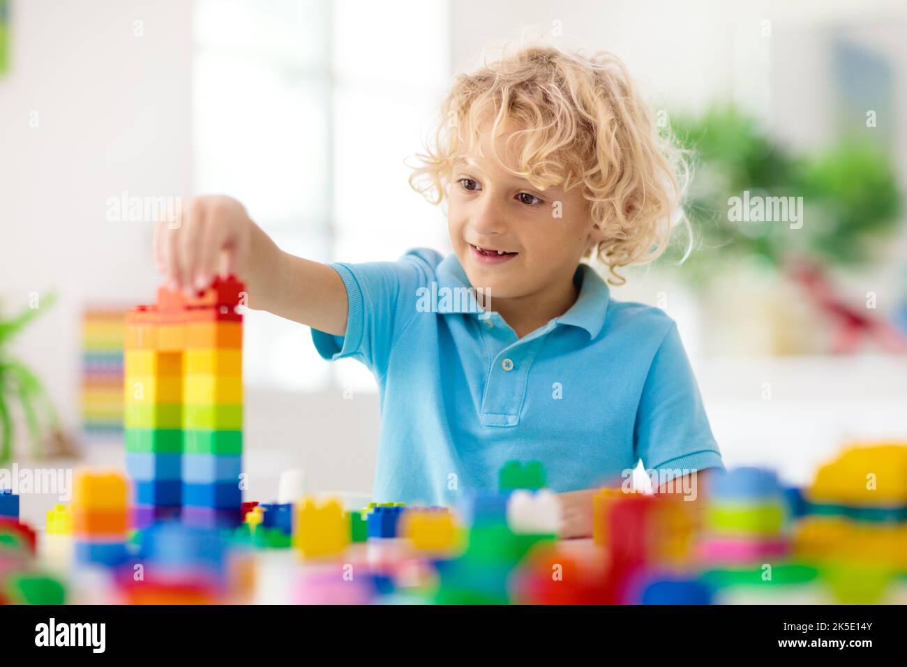 Kids play with colorful blocks. Little boy building tower at home or ...