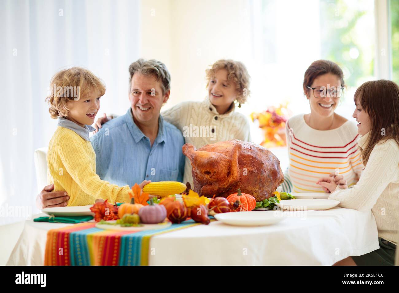 Family at Thanksgiving dinner. Parents and kids enjoy roasted turkey ...