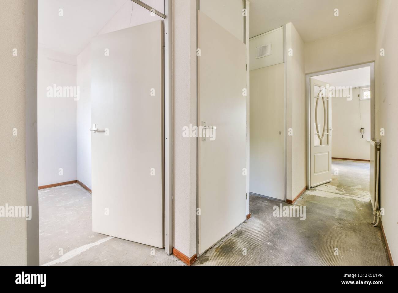 Light narrow hallway with many doors in white walls Stock Photo - Alamy