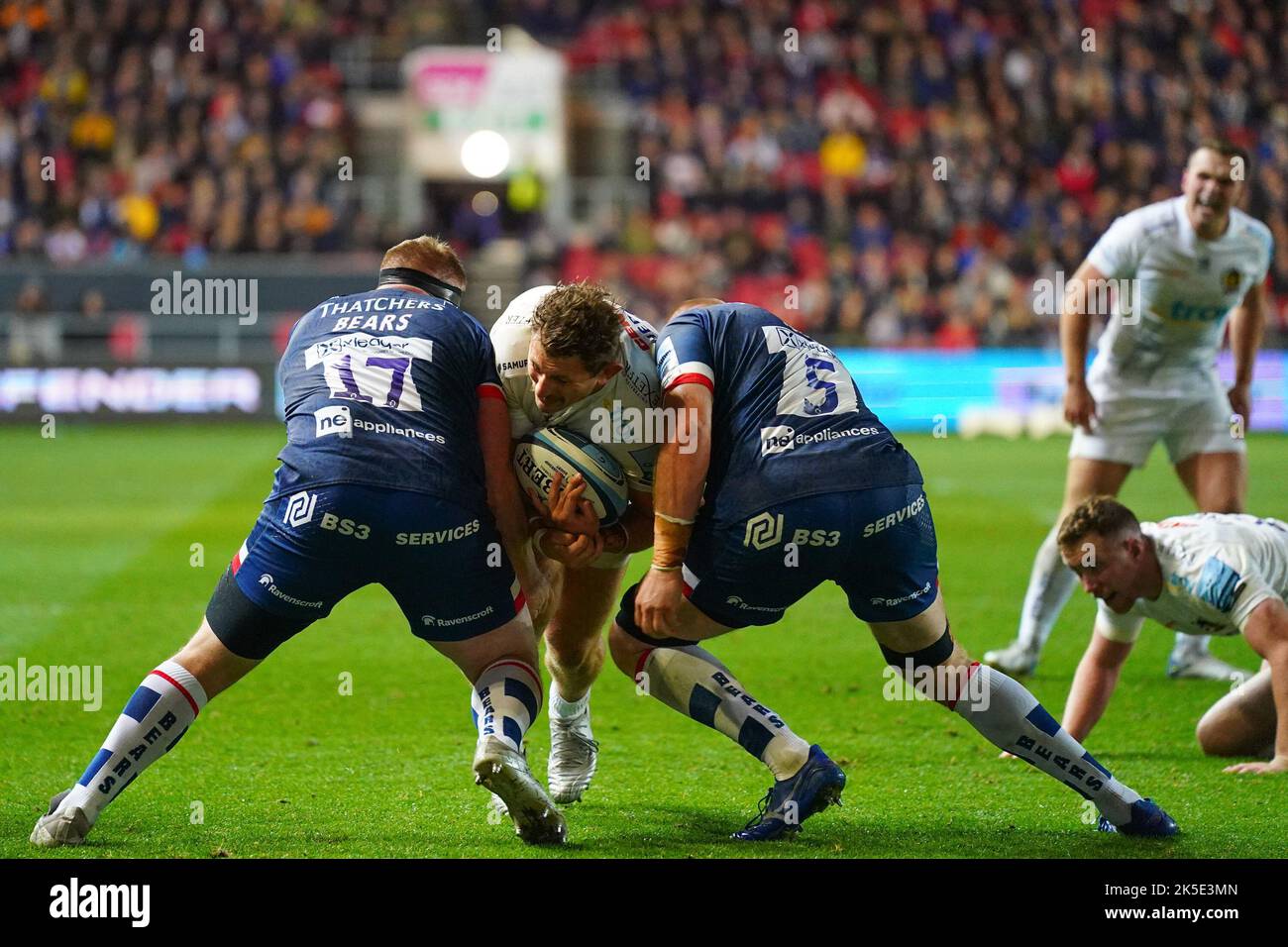 Alec Hepburn of Exeter Chiefs gets sandwiched by Jake Woolmor of ...