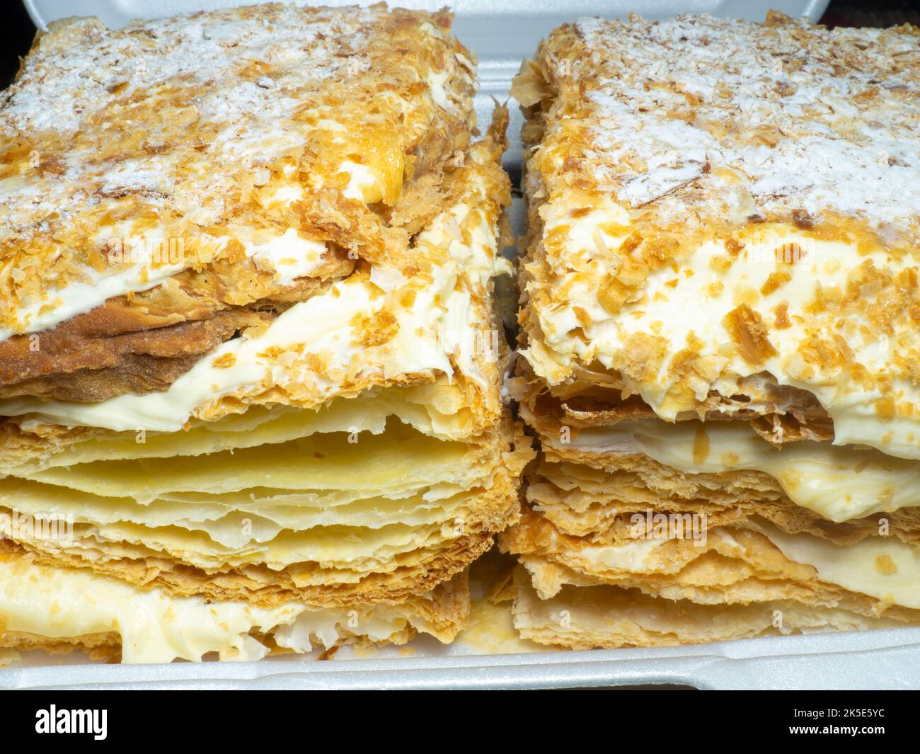 Cut pieces of cake. Napoleon cake close-up. Sweets for tea. A flaky ...