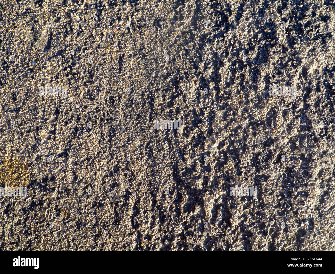 The structure of the material. Uneven sand surface. Under your feet ...