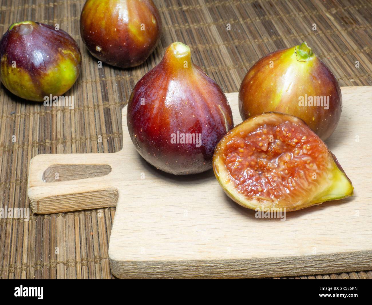 Juicy ripe figs on a cutting board. Halves of figs. Southern fruits on ...