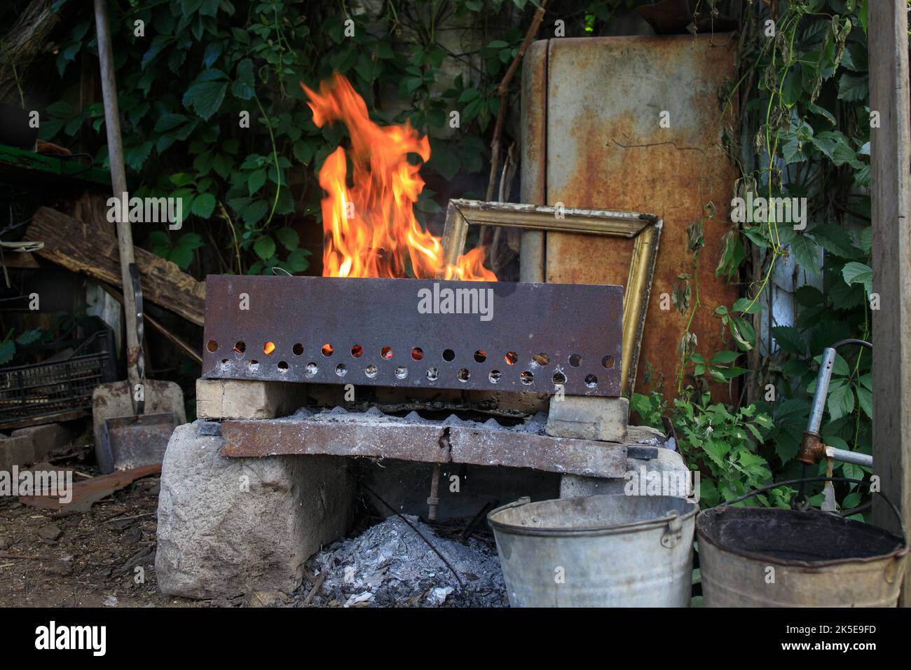 a fire in an old brazier in a dump of things Stock Photo - Alamy