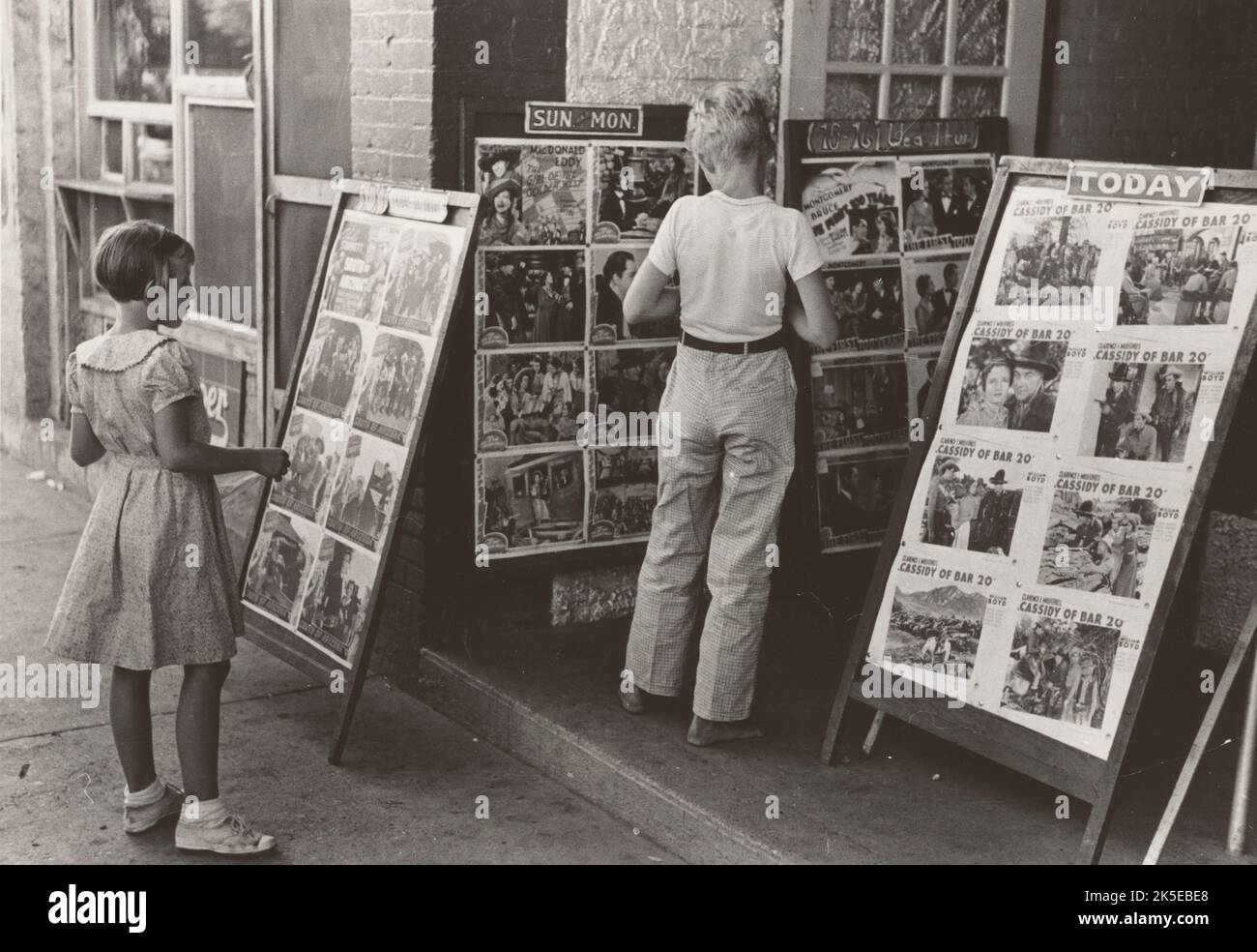 Children looking at posters in front of movie, Saturday, Steele ...
