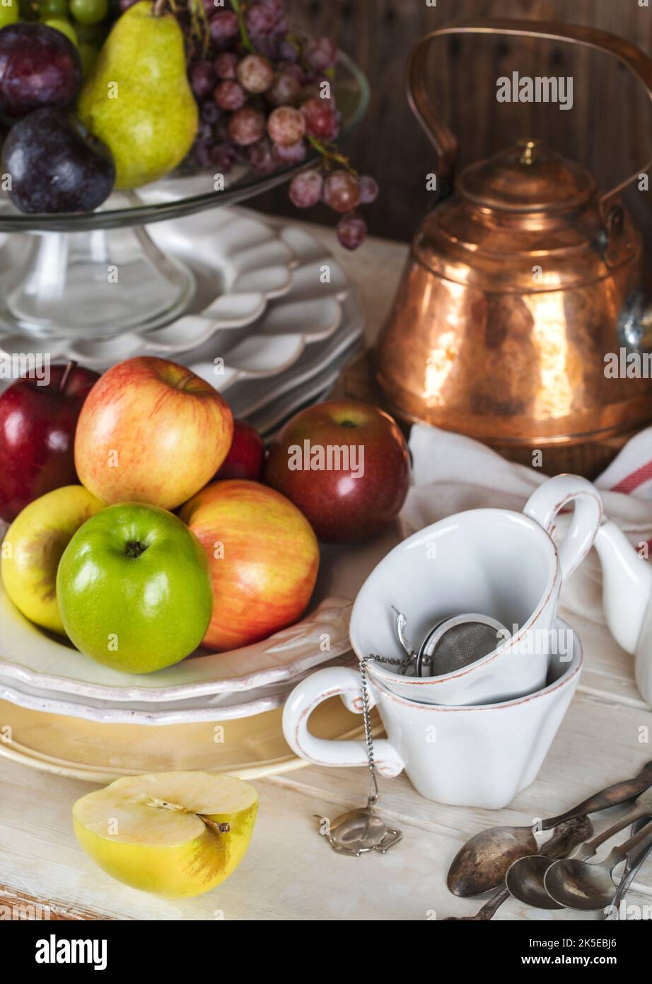 Autumn fruits, plates, cutlery and kitchen utencils on wooden table ...