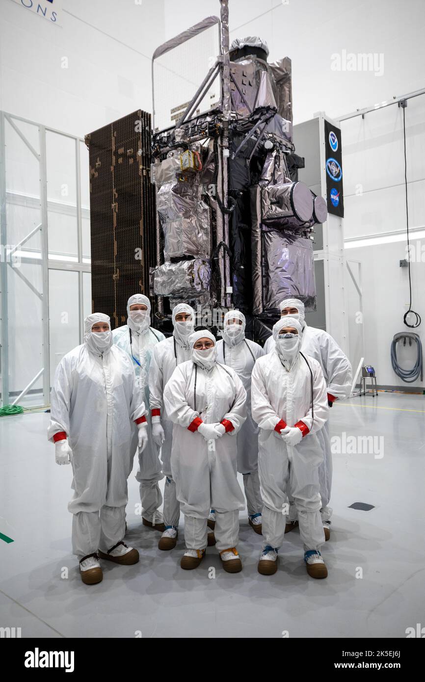 Dressed in clean-room suits, processing team members stand in front of ...