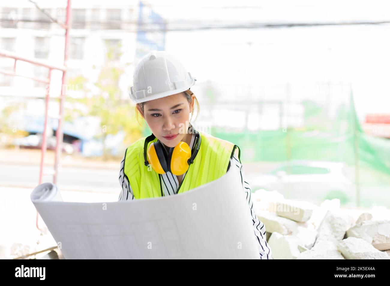 Asian engineer or Young woman Architect put on a helmet for safety and ...