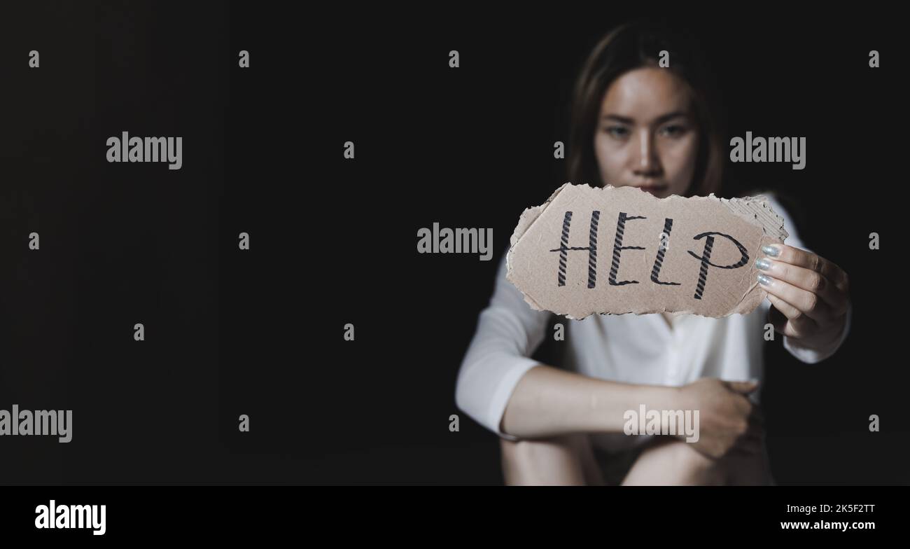 Women sitting alone with depressed expression and showing a paper with ...