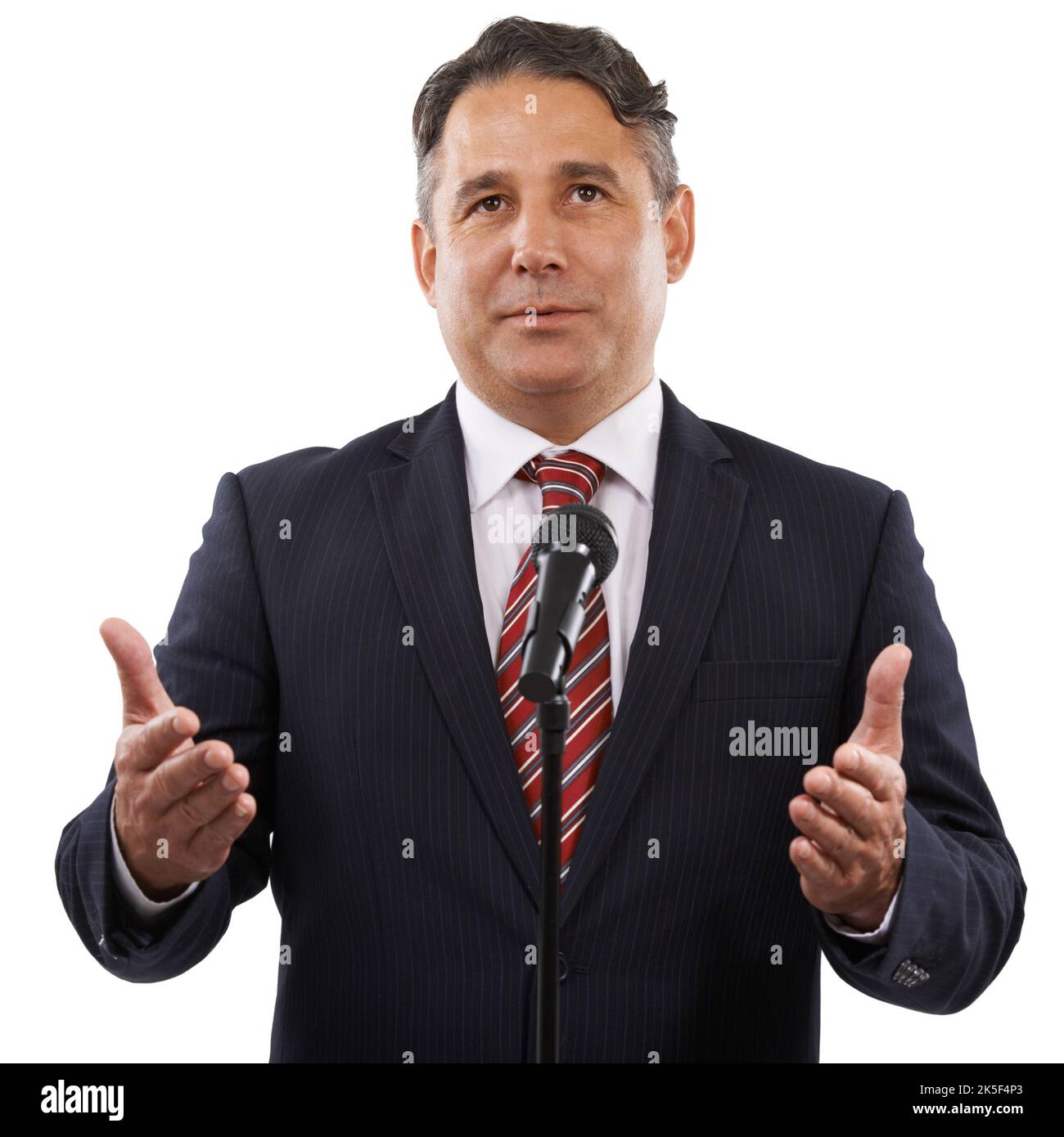 Inspiring trust. A man in a suit with his hands raised while saying a ...