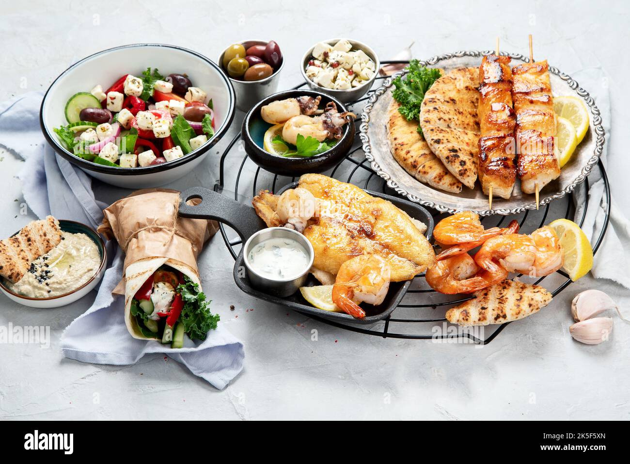 Greek food background. Meze, gyros, souvlaki, fish, pita, greek salad ...