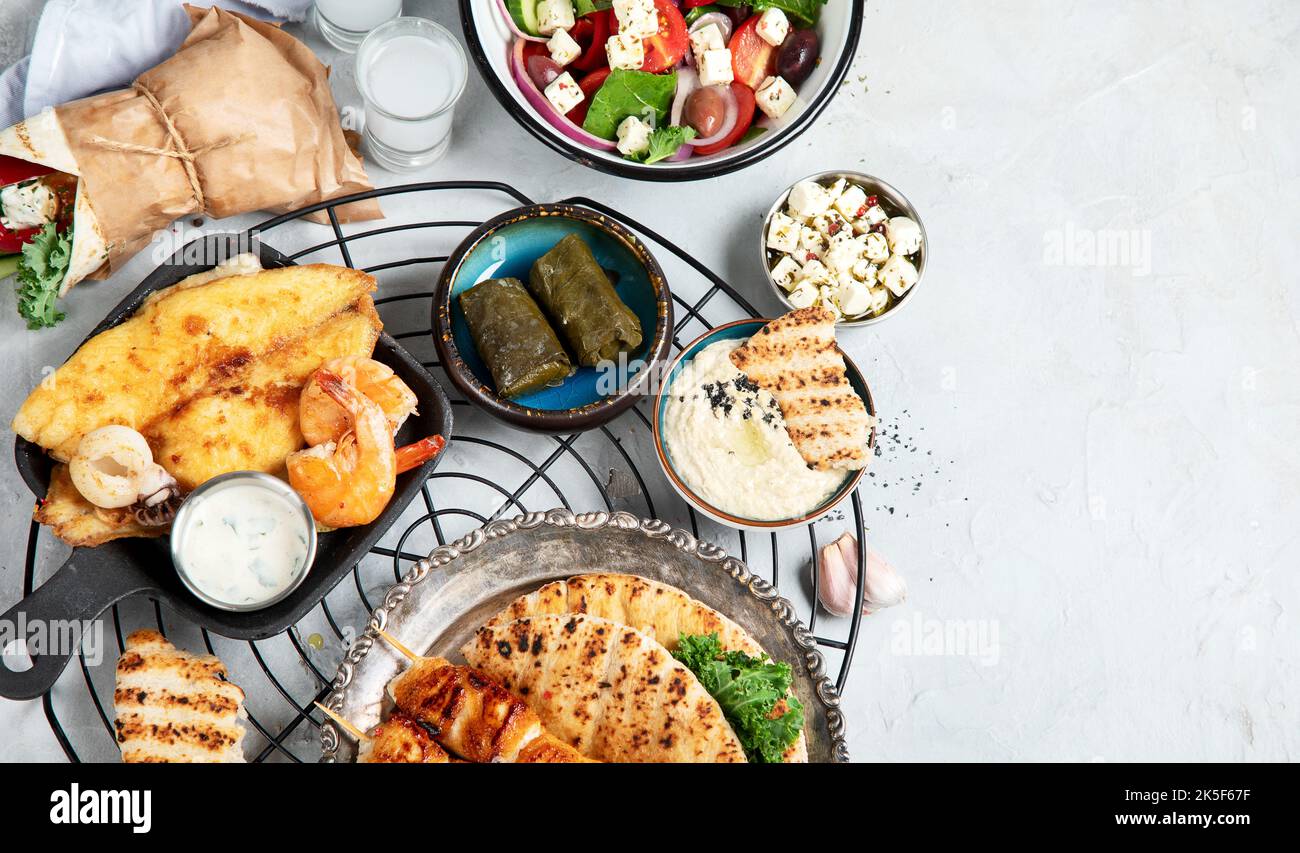 Greek food background. Meze, gyros, souvlaki, fish, pita, greek salad ...