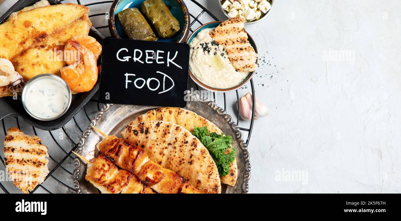 Greek food background. Meze, gyros, souvlaki, fish, pita, greek salad ...