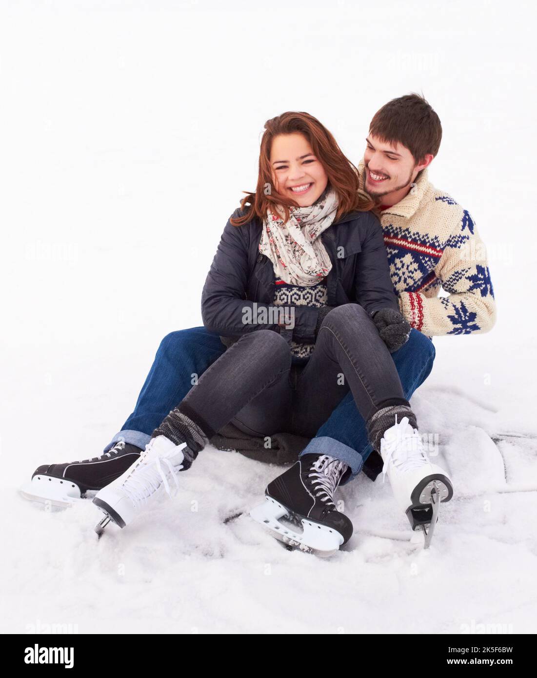 Fun and games on the ice. Young couple laughing and being silly on the ...