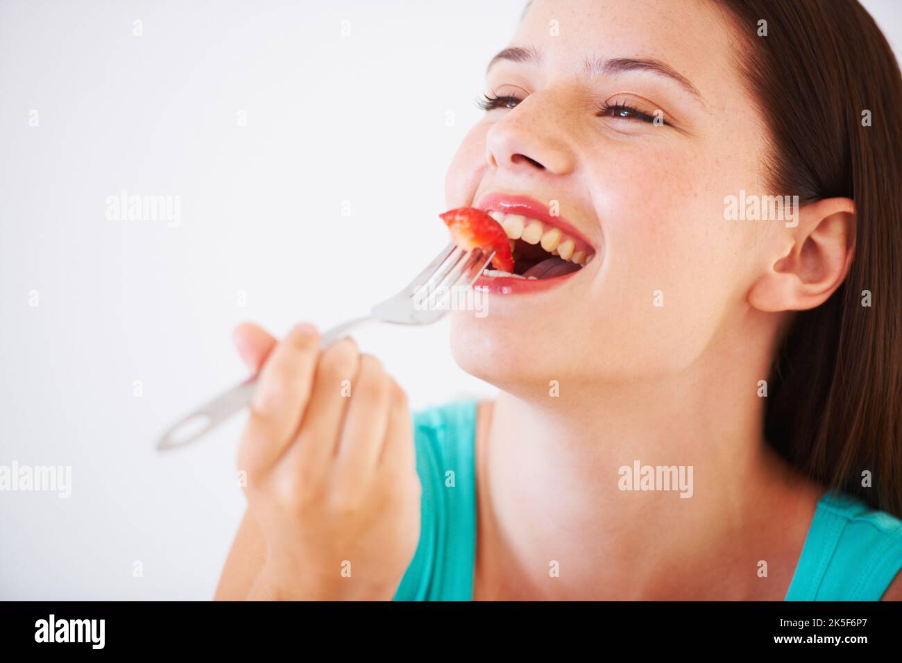 She loves her fruit. An attractive young woman eating some fruit Stock ...