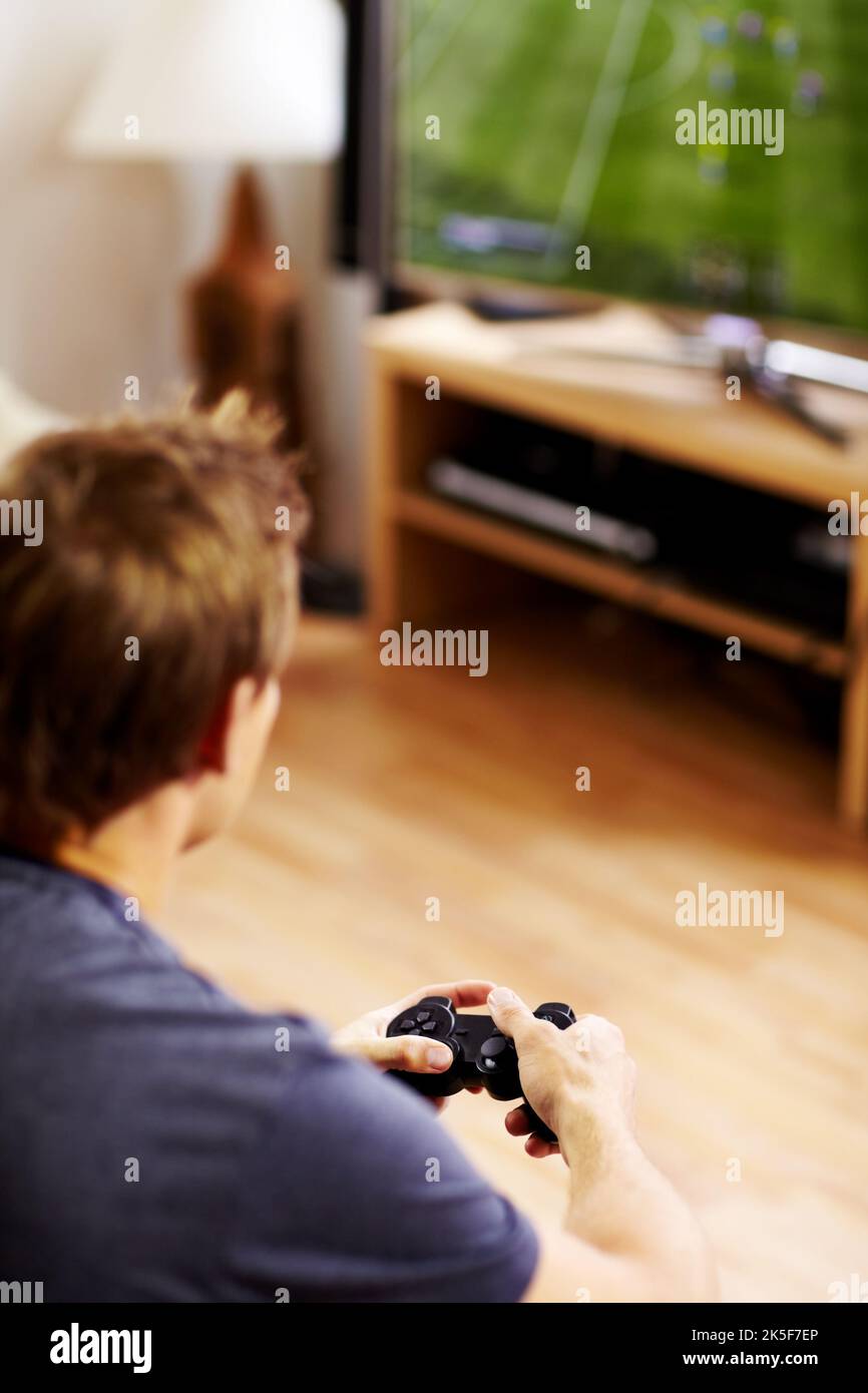 Engrossed in the game. Handsome guy playing a video game using a ...