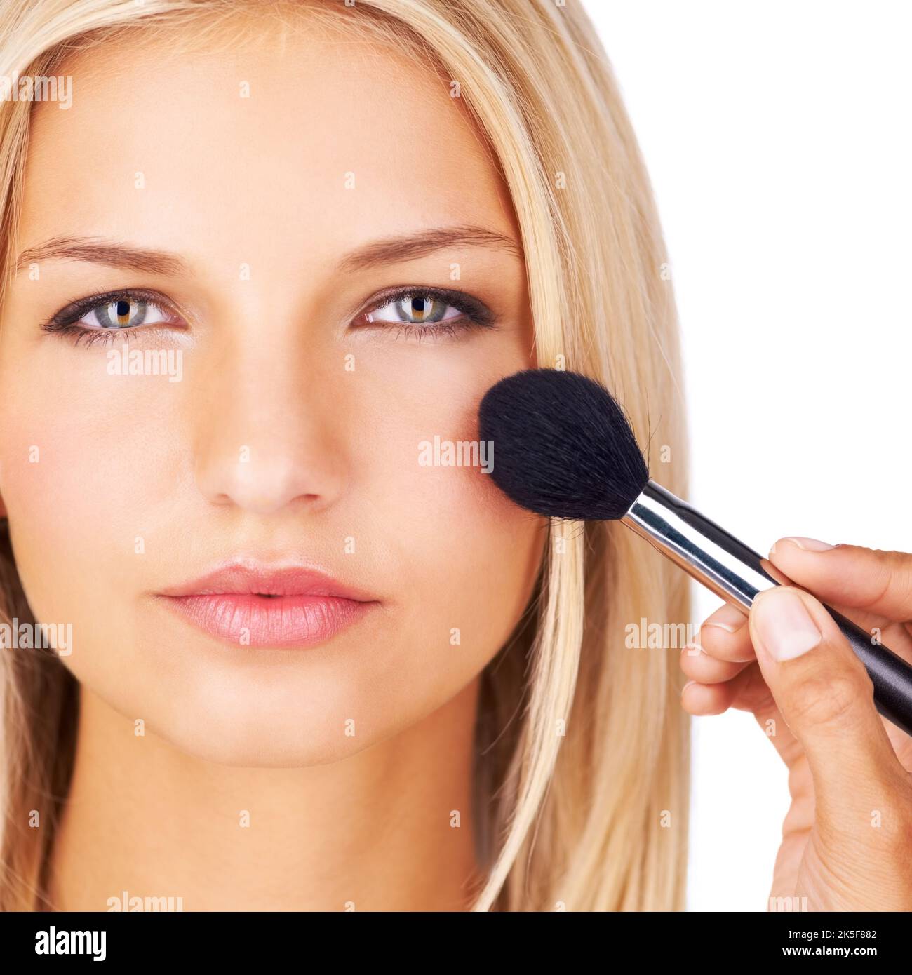 Adding a pop of color. Cropped view of a young woman having blusher ...