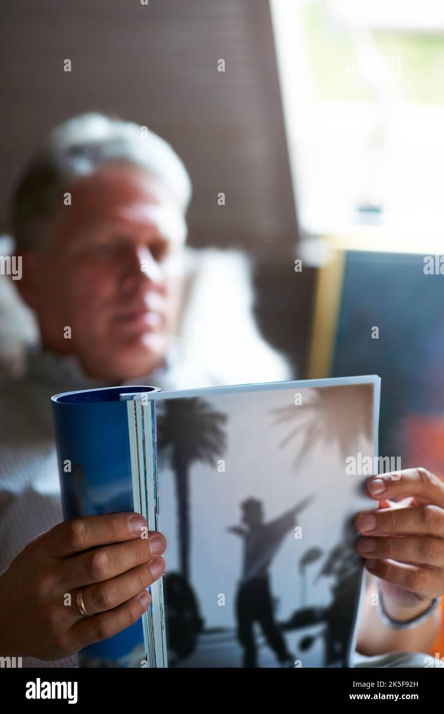 Relaxing with his favourite magazine. a senior man reading a magazine ...