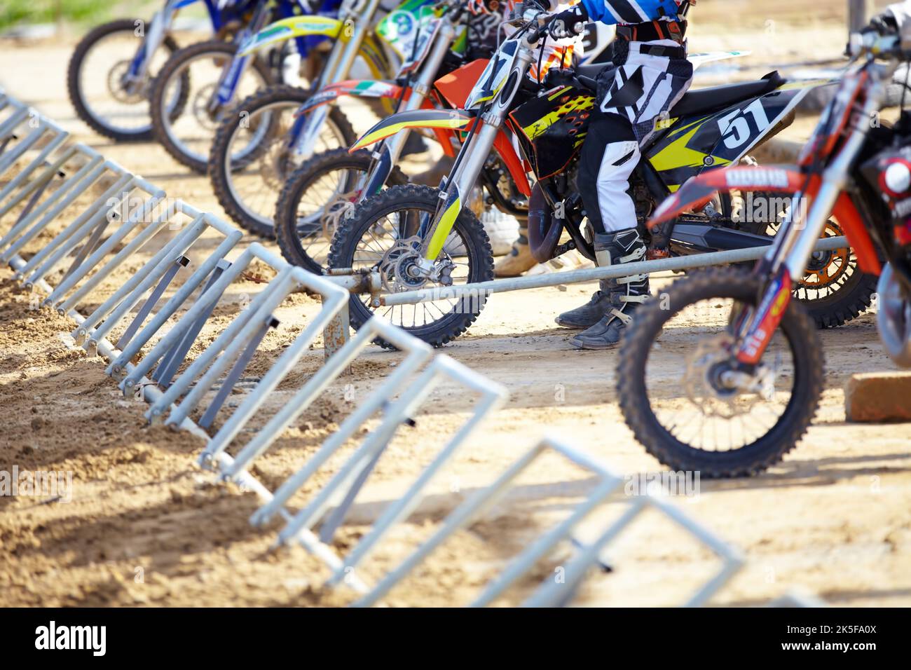 Riders To your mark. A group of motocross riders waiting at the gate ...