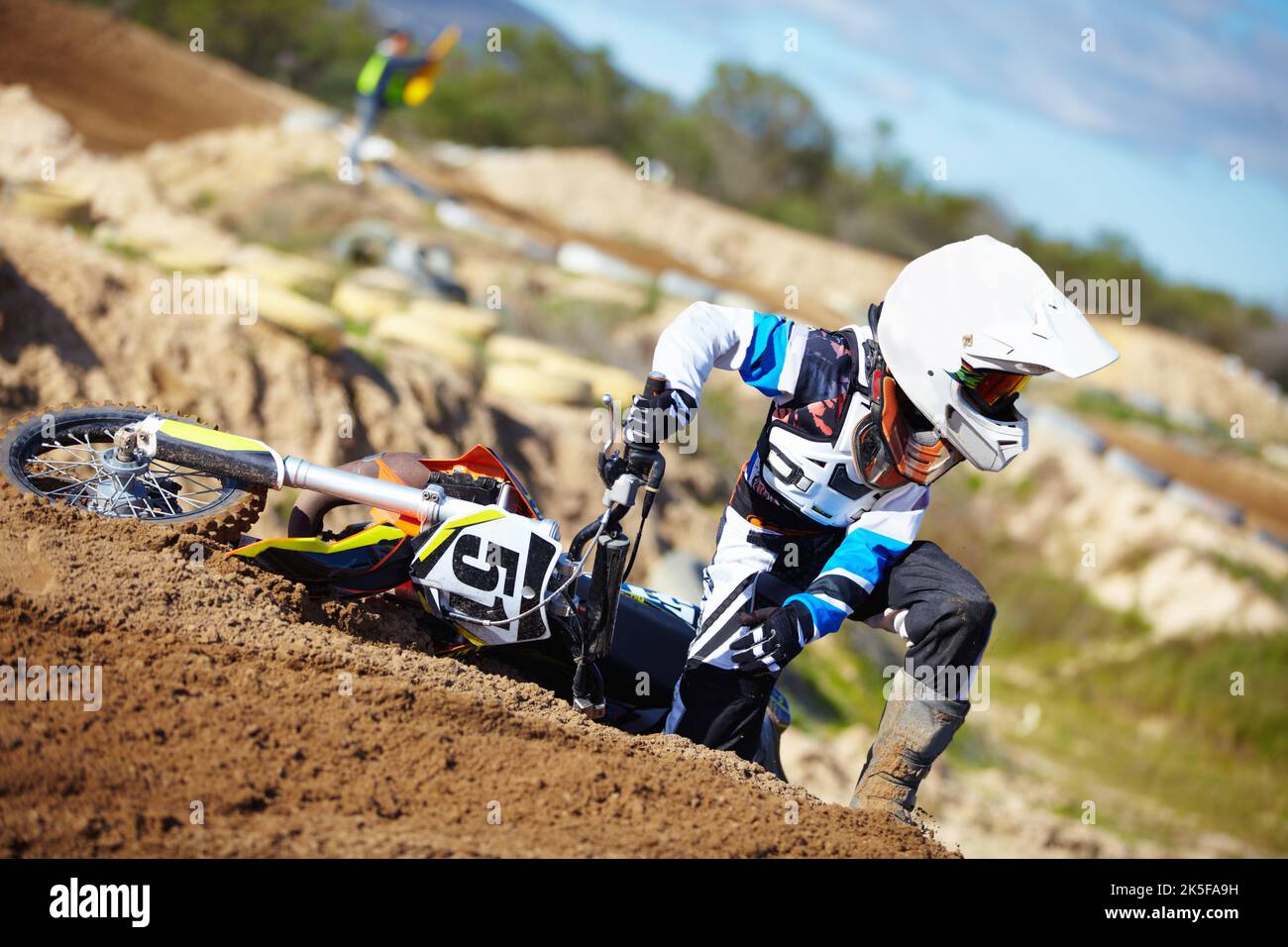 Get up and go again. A motocross rider picking up his bike after a fall ...