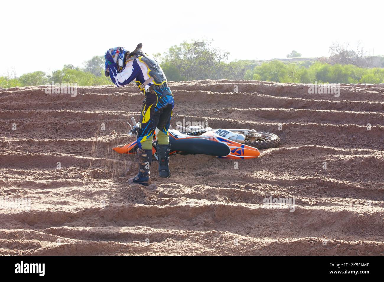 Pick yourself up and try again. A motocross rider getting up after ...