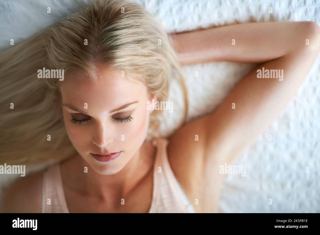Catching some shut eye. An attractive young woman lying with her eyes closed on her bed Stock ...