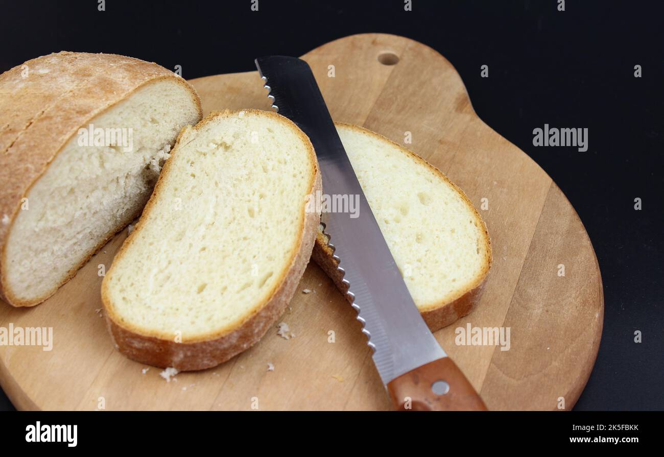 Cutting loaf of bread with knife on cutting board Stock Photo - Alamy
