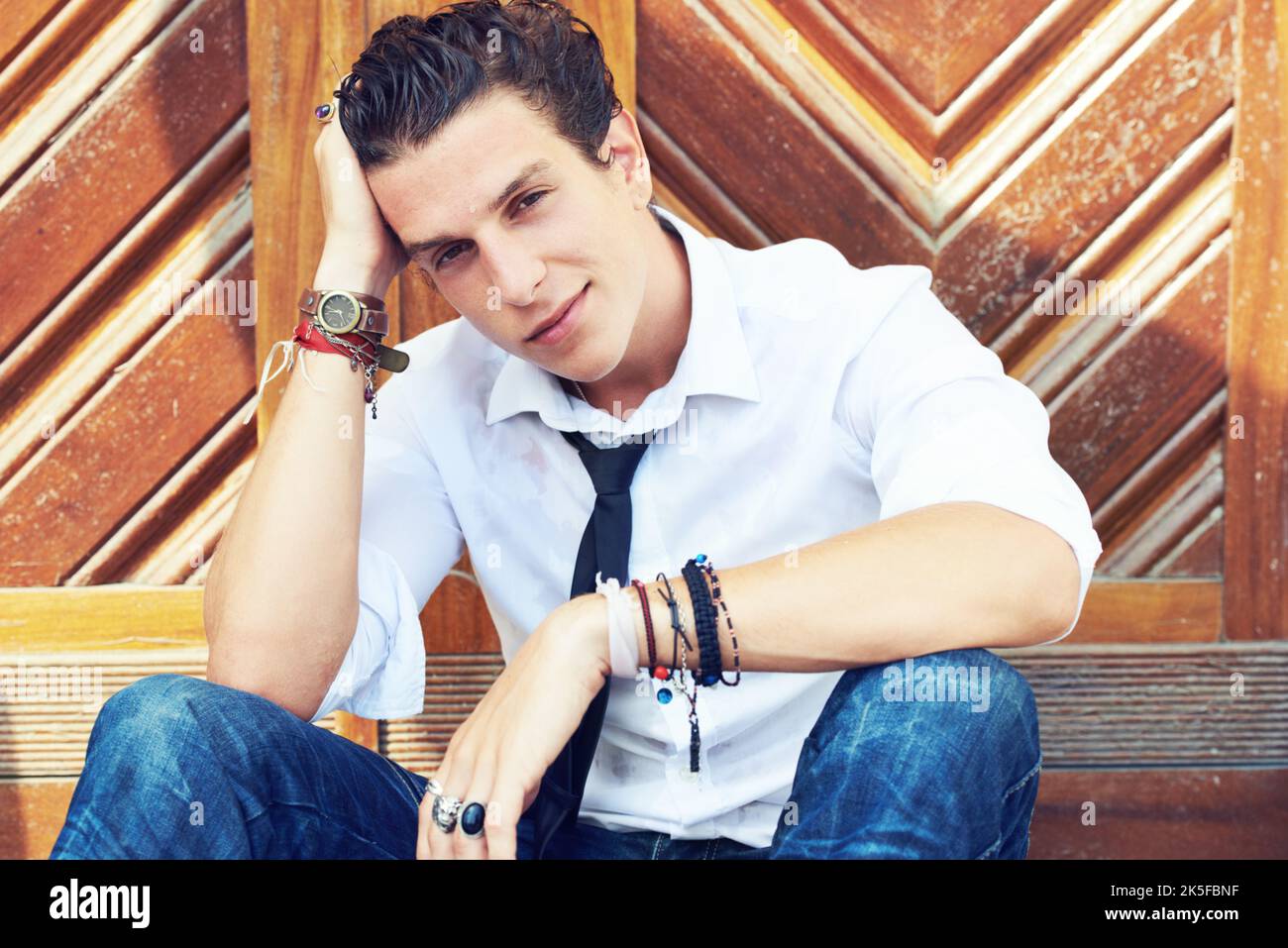 Urban sophistication. Portrait of a stylish young man resting his head ...