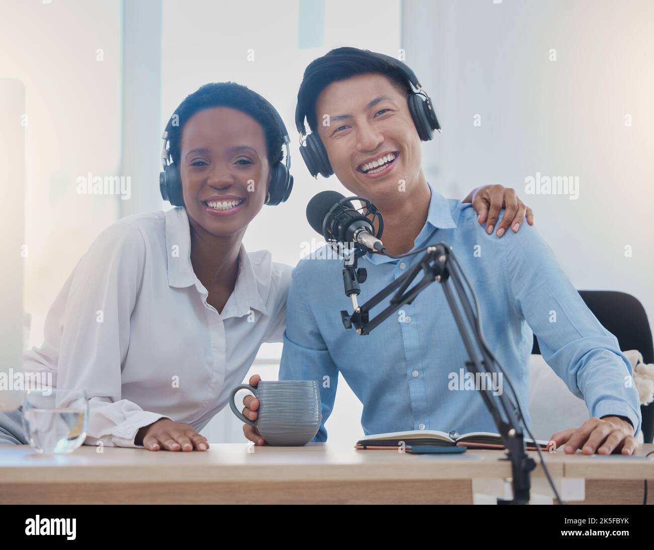 Happy, smile and portrait of radio employees sitting in the studio with ...