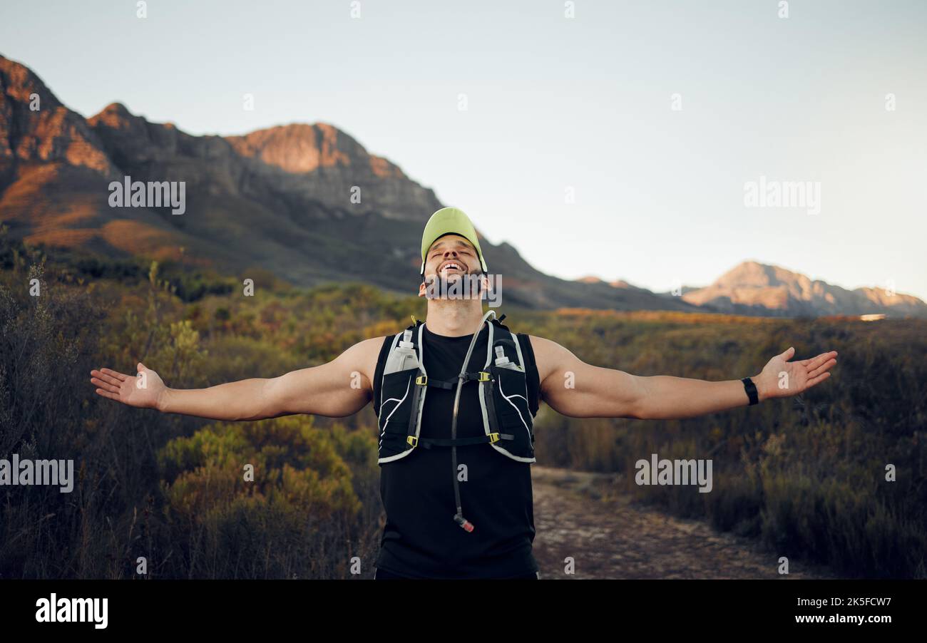Fitness, achievement and winner of a man in nature embracing freedom ...