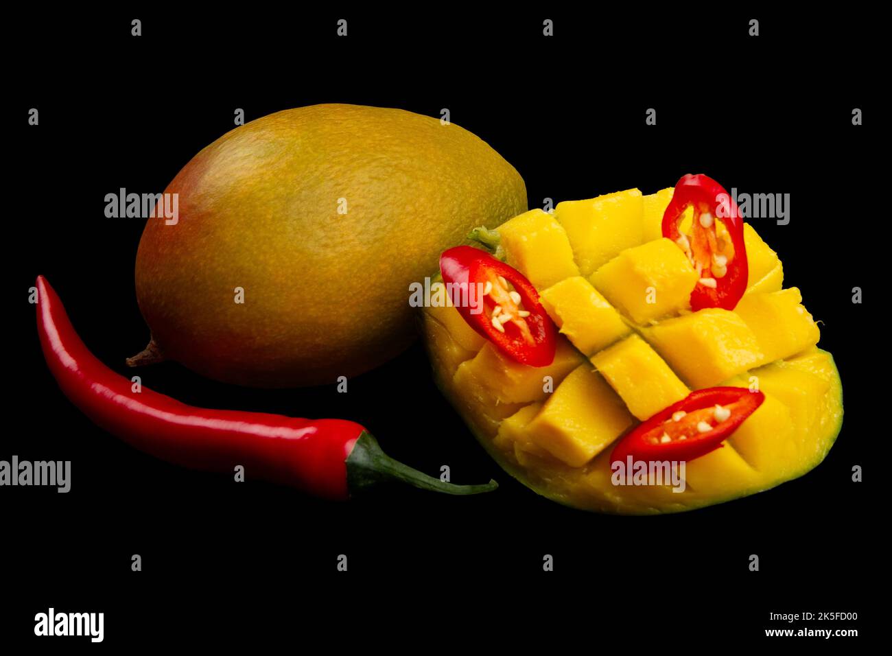 Whole mango, whole chili pepper, sliced hot pepper and cutted half of ...