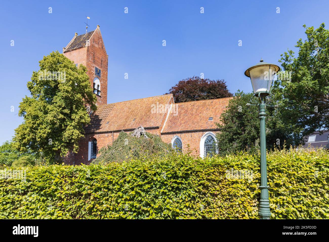 Classic church from 13th century surrounded by big trees in Tolbert ...