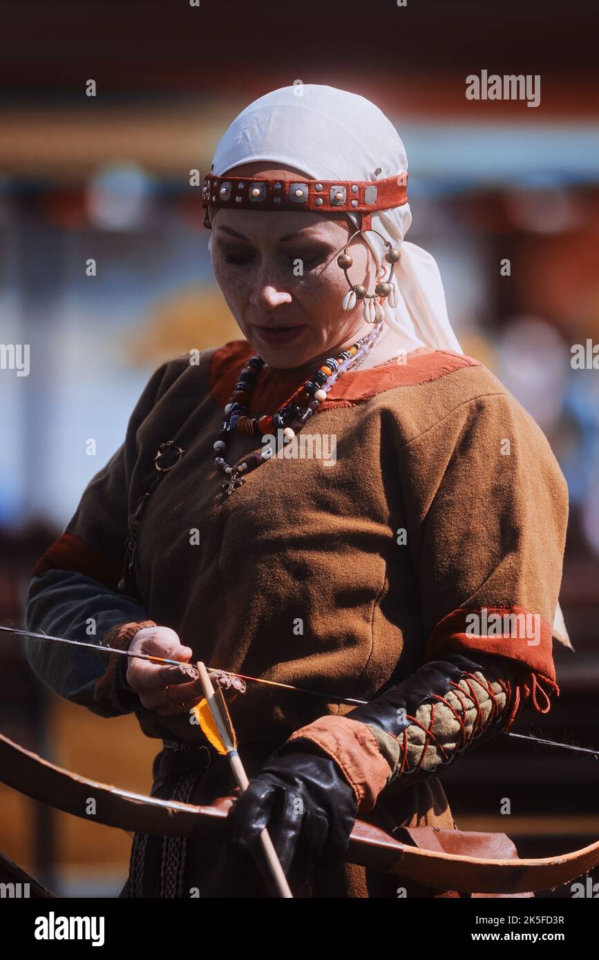 Medieval archery tournament. A woman shoots an arrow in the medieval ...