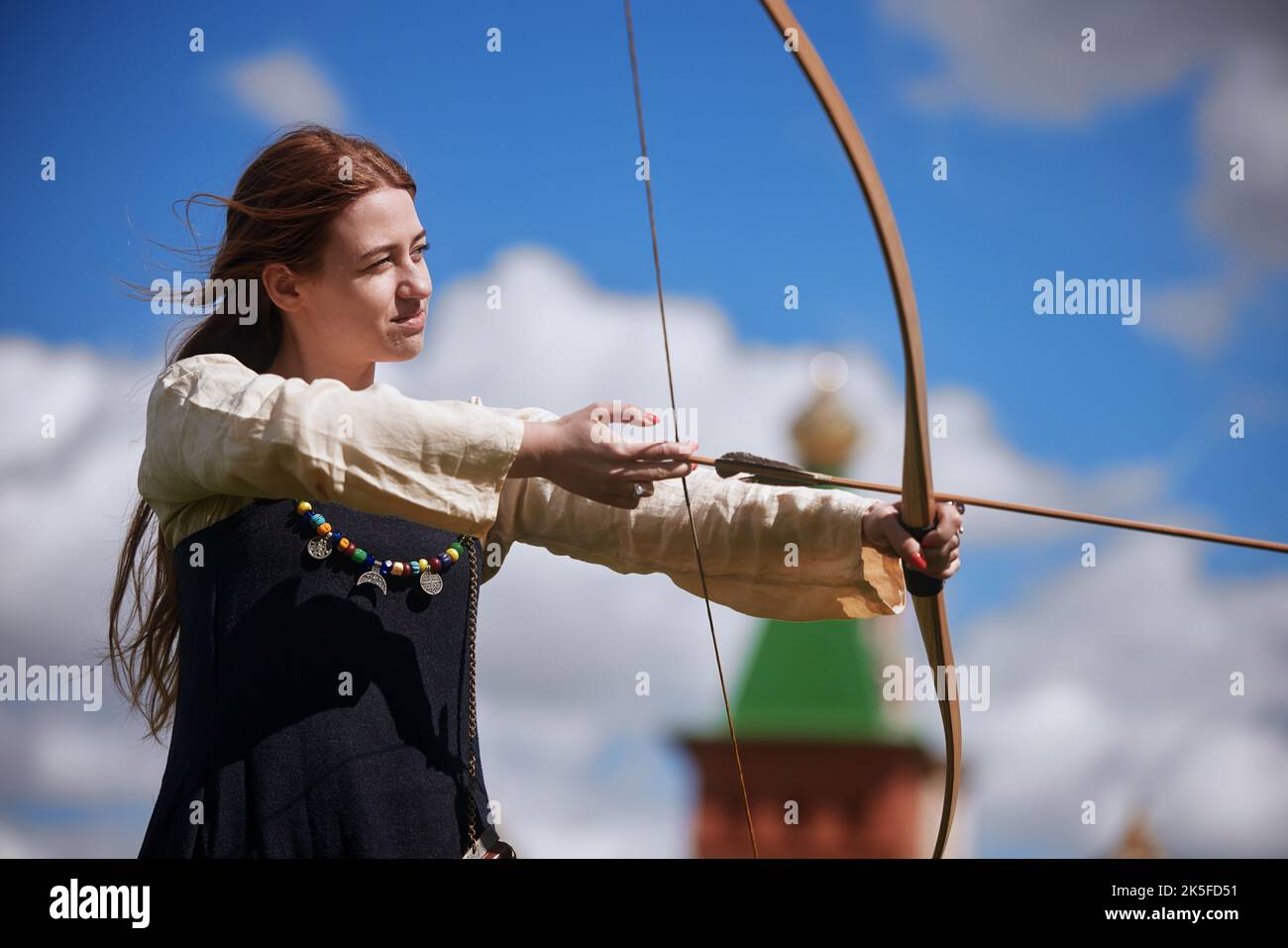 Medieval archery tournament. A woman shoots an arrow in the medieval ...