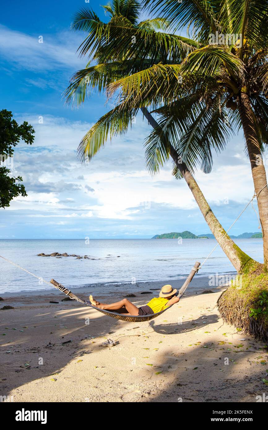 Girl lying under palm tree hi-res stock photography and images - Alamy