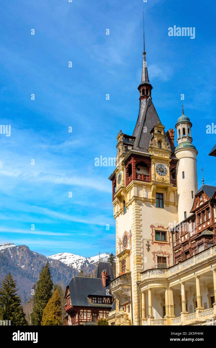 Peles castle tower close-up view and Carpathian mountains snow peaks ...