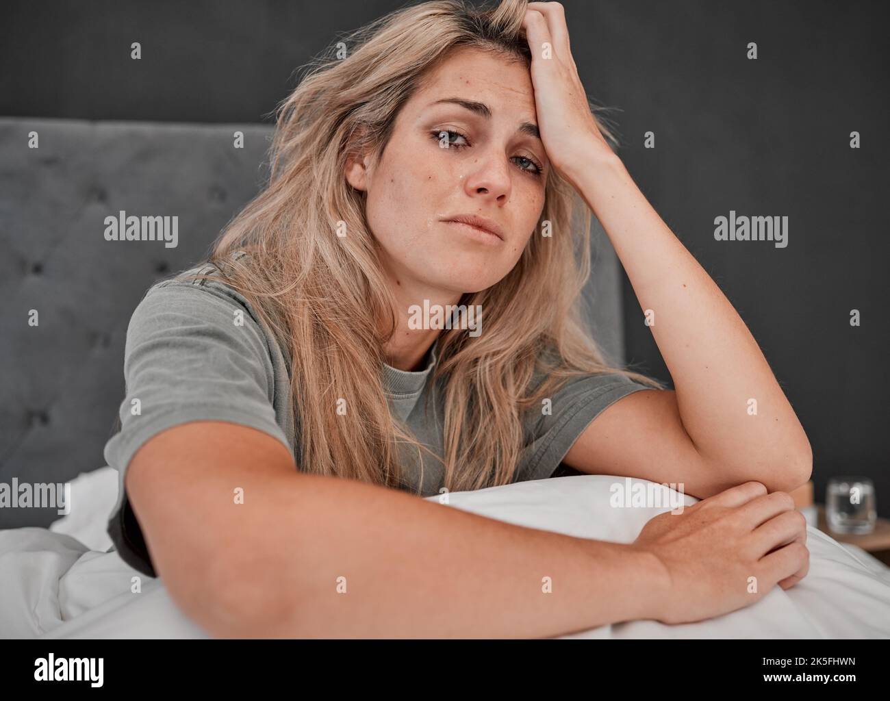 Depression, tired and portrait of a sick woman sitting on the bed in ...