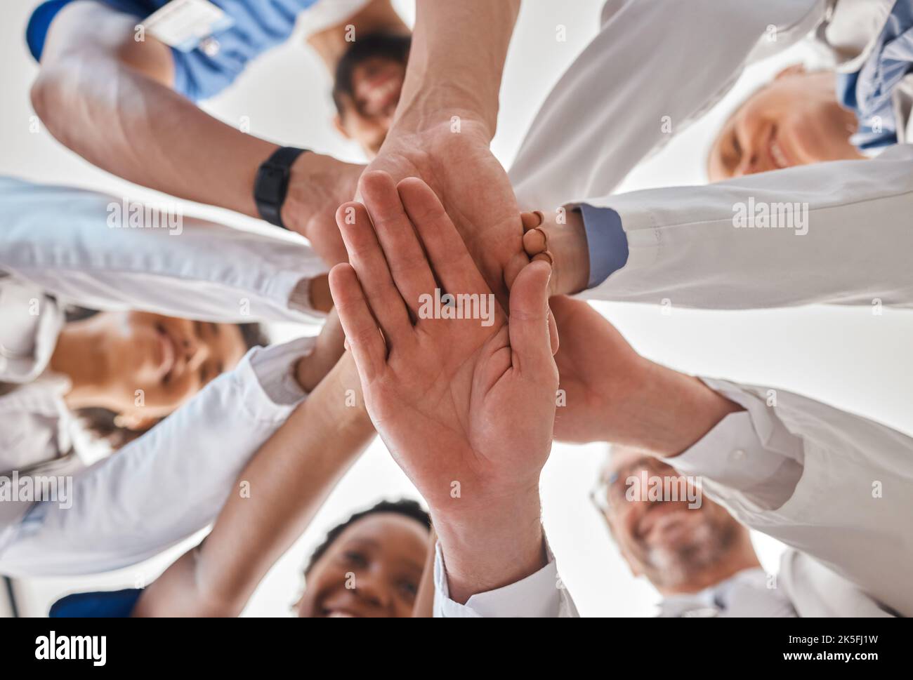 Hands, doctor and teamwork below in hospital for motivation, inspiration and diversity at work ...