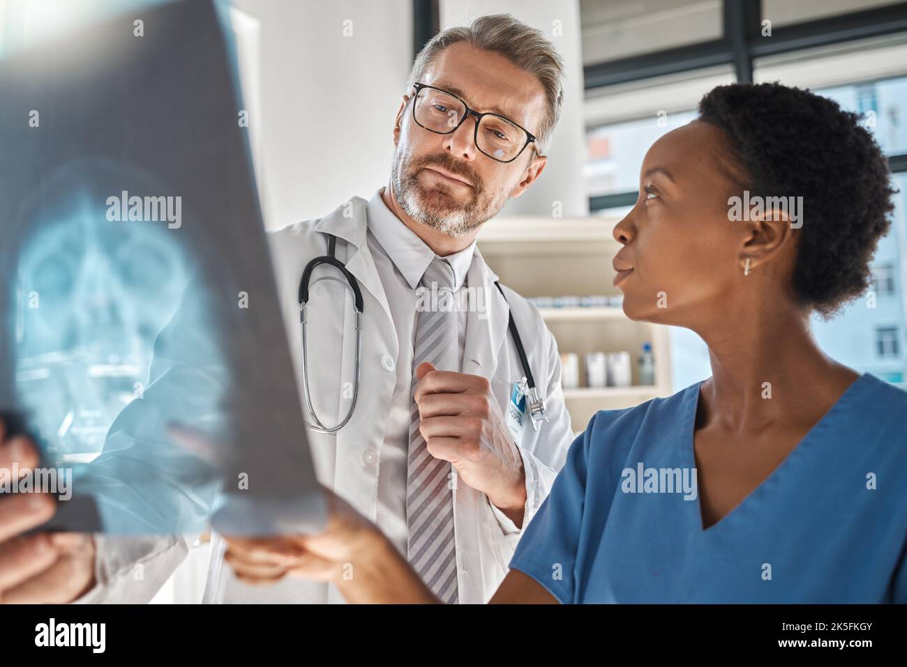 Brain, x ray and neurology doctors in a meeting working on a skull injury in emergency room in a ...